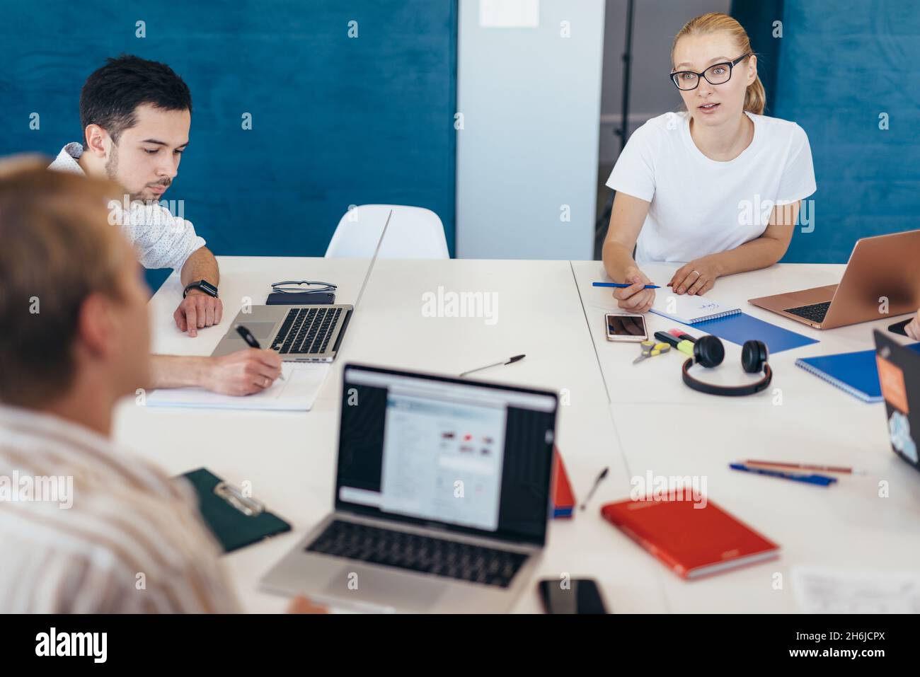 Staff communicate at work by sitting at desk Stock Photo - Alamy