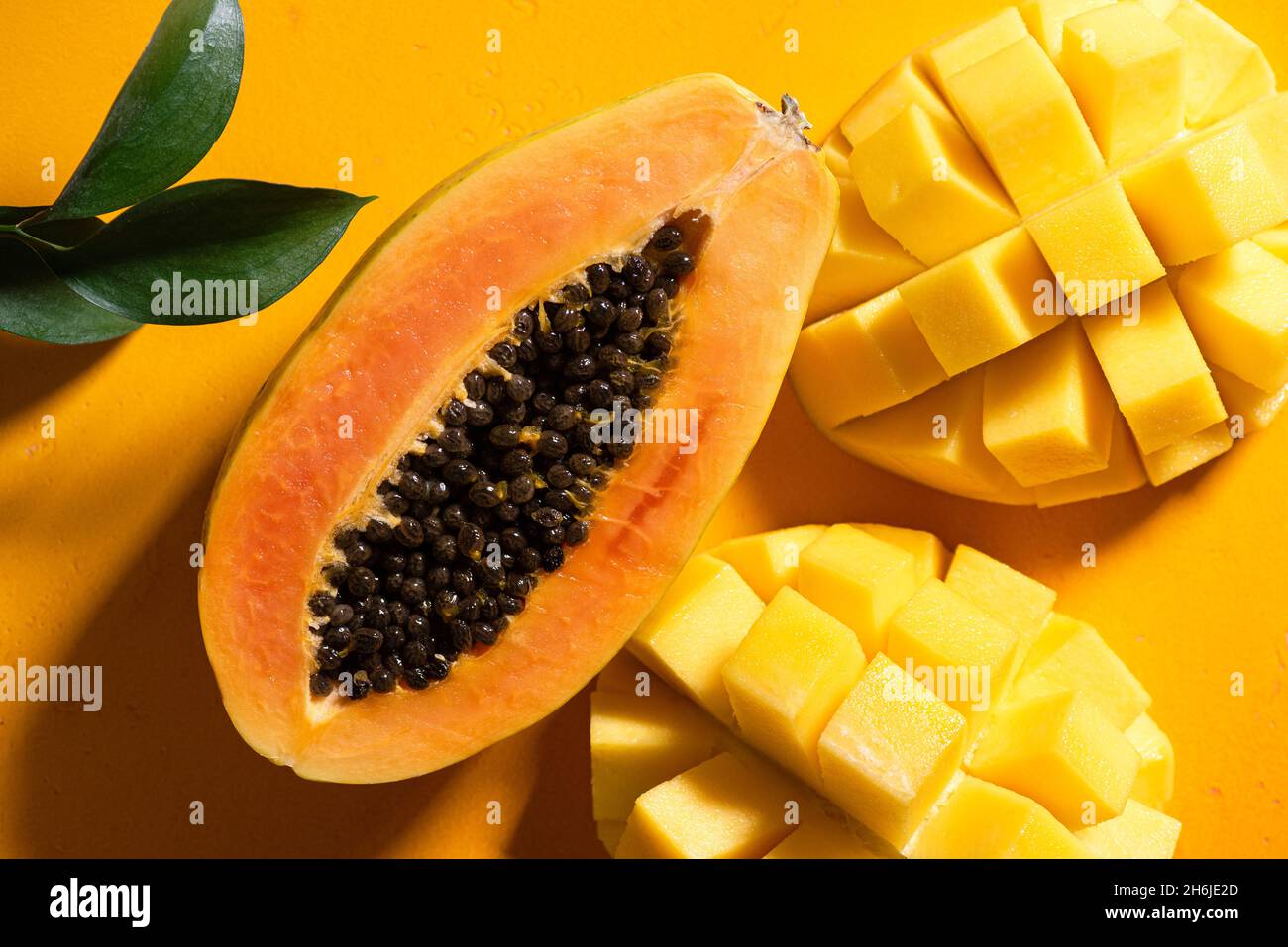 Papaya and mango tropical fruits on yellow background flat lay with ...
