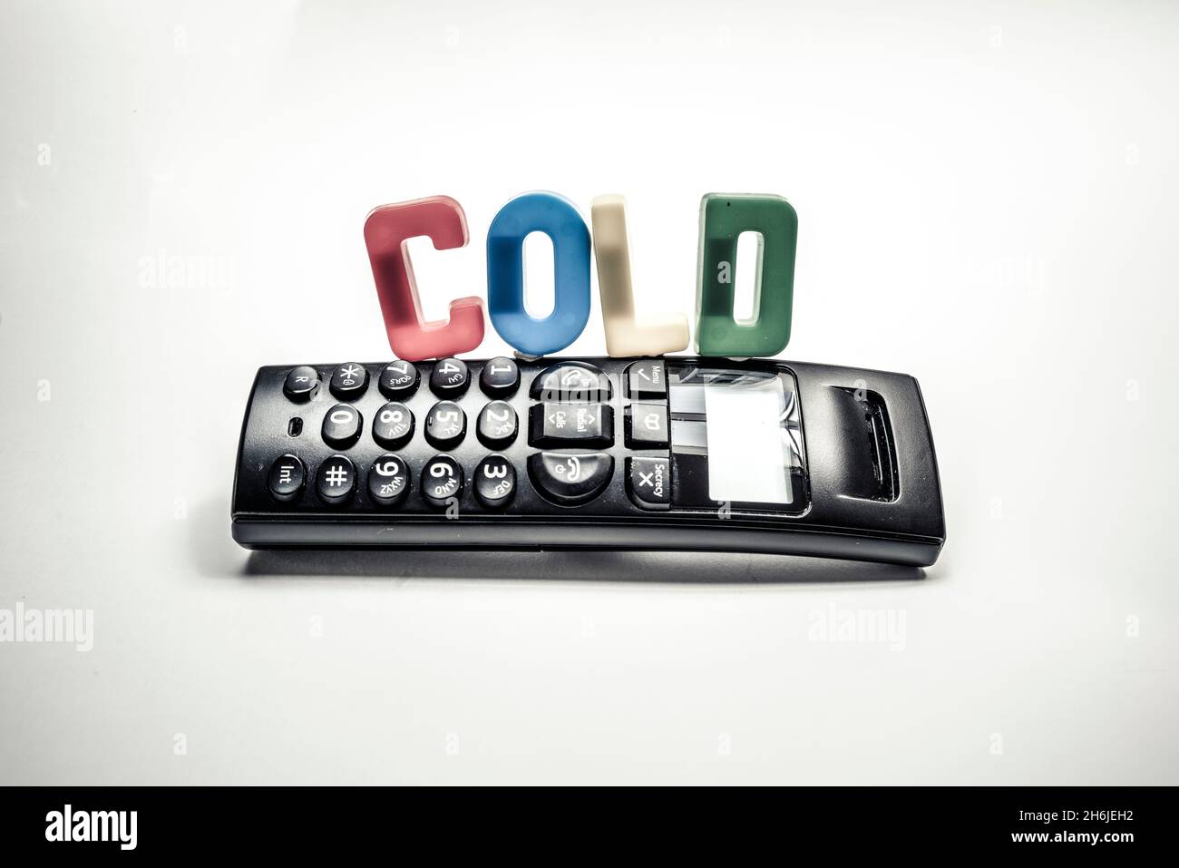 plastic letters spelling out COLD on top of a phone, symbolising cold ...