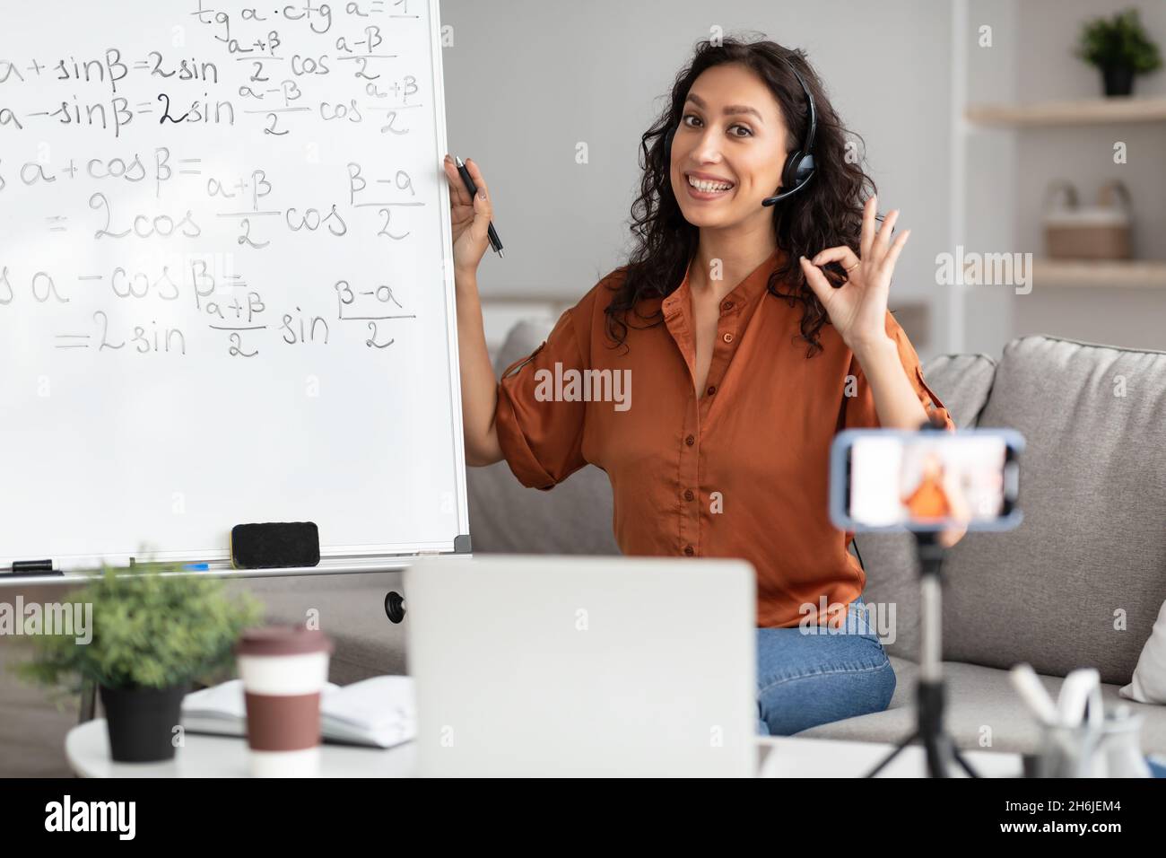 Female teacher showing okay gesture, explaining math to students Stock ...