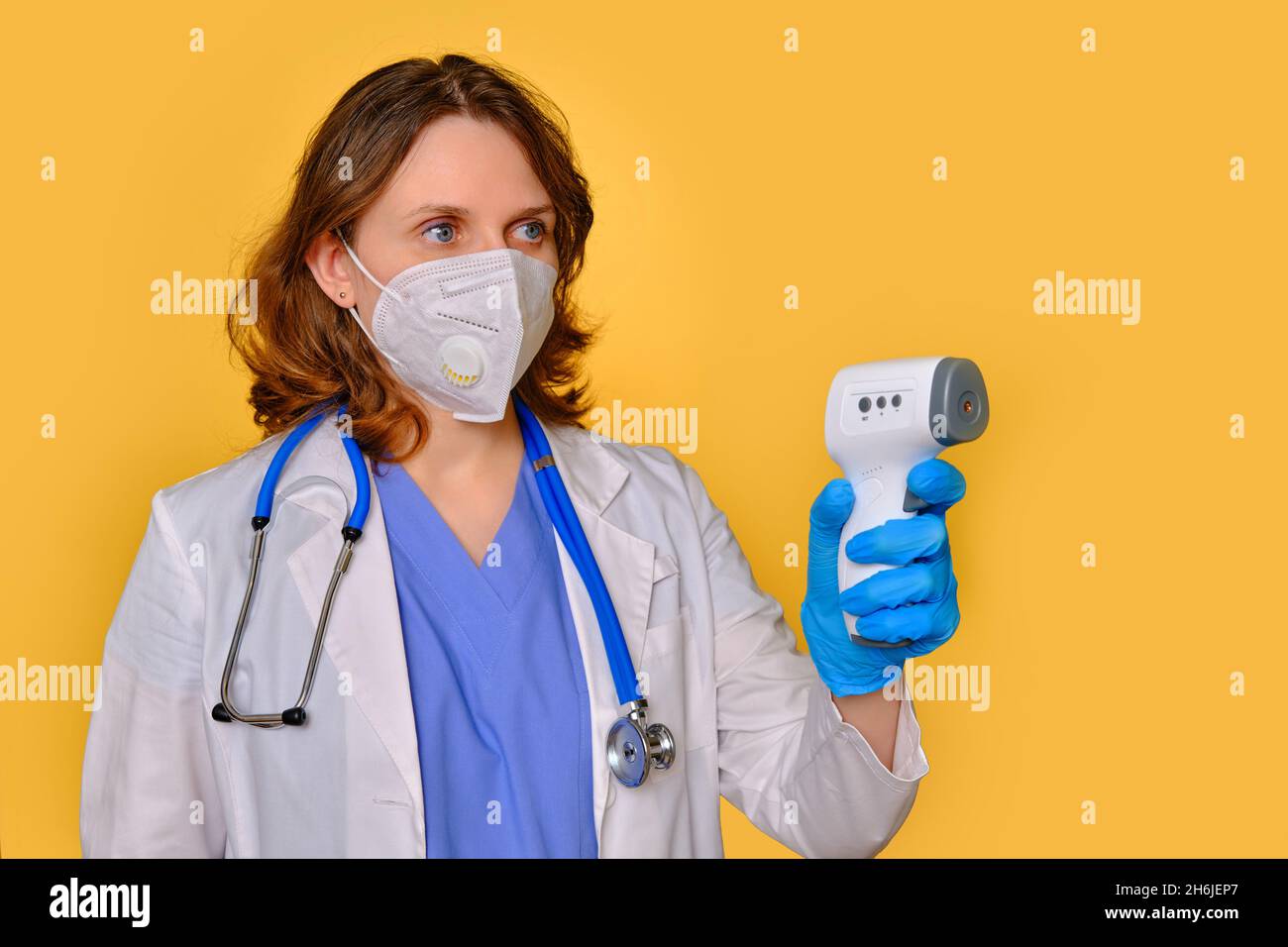 Woman nurse with a thermometer on studio background, face closeup Stock ...