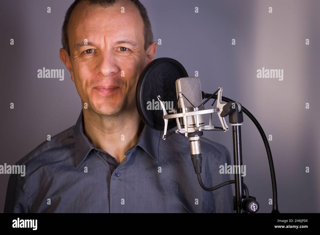 Voiceover artist voice actor in vocal recording studio with larg ...