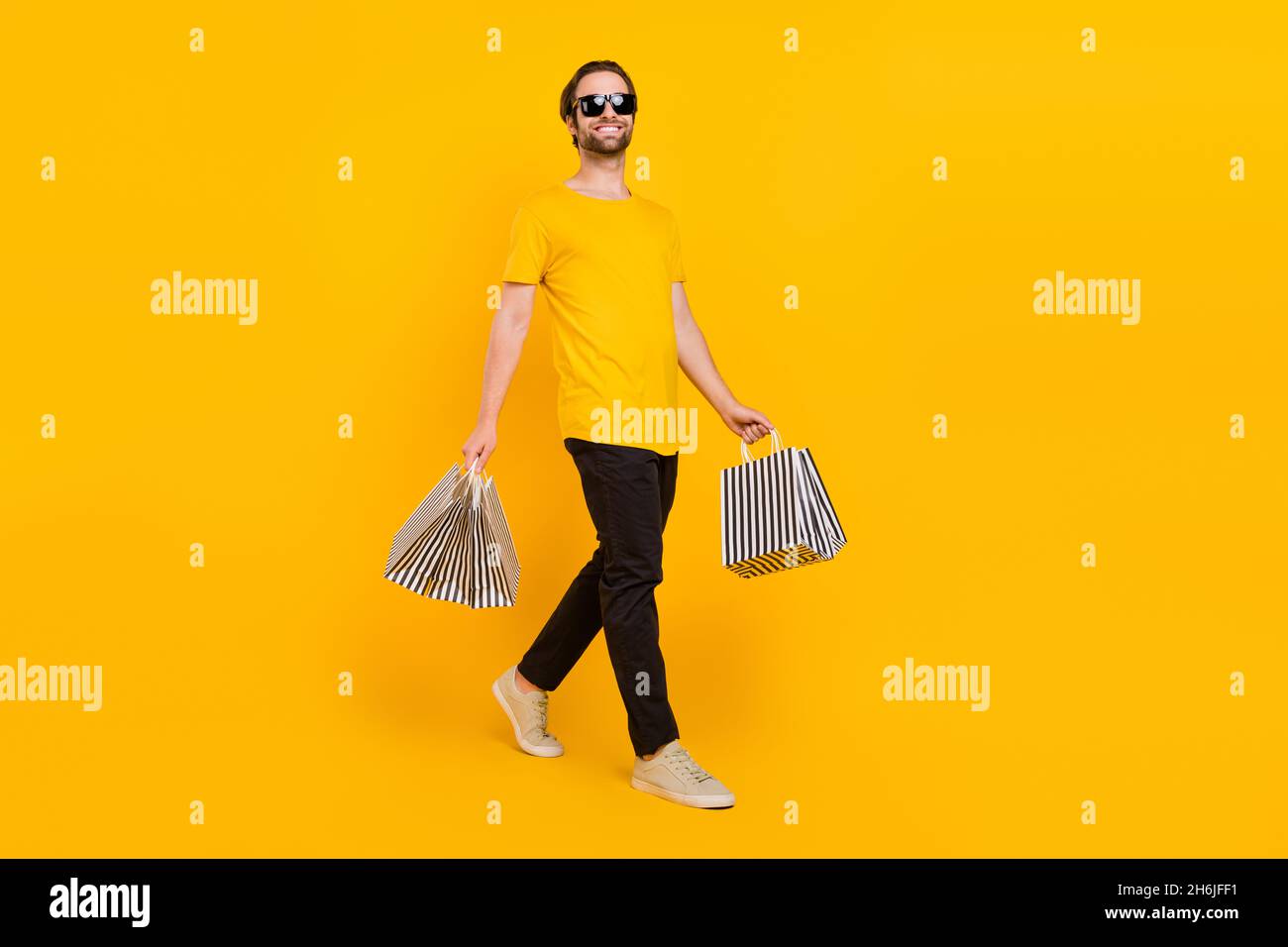 Full size photo of young cheerful guy step hold package shop deliver ...