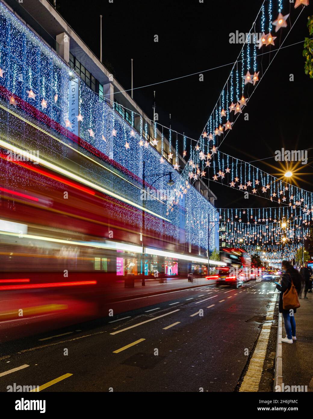 A commuter waits for a bus on a very busy Oxford Street during the ...