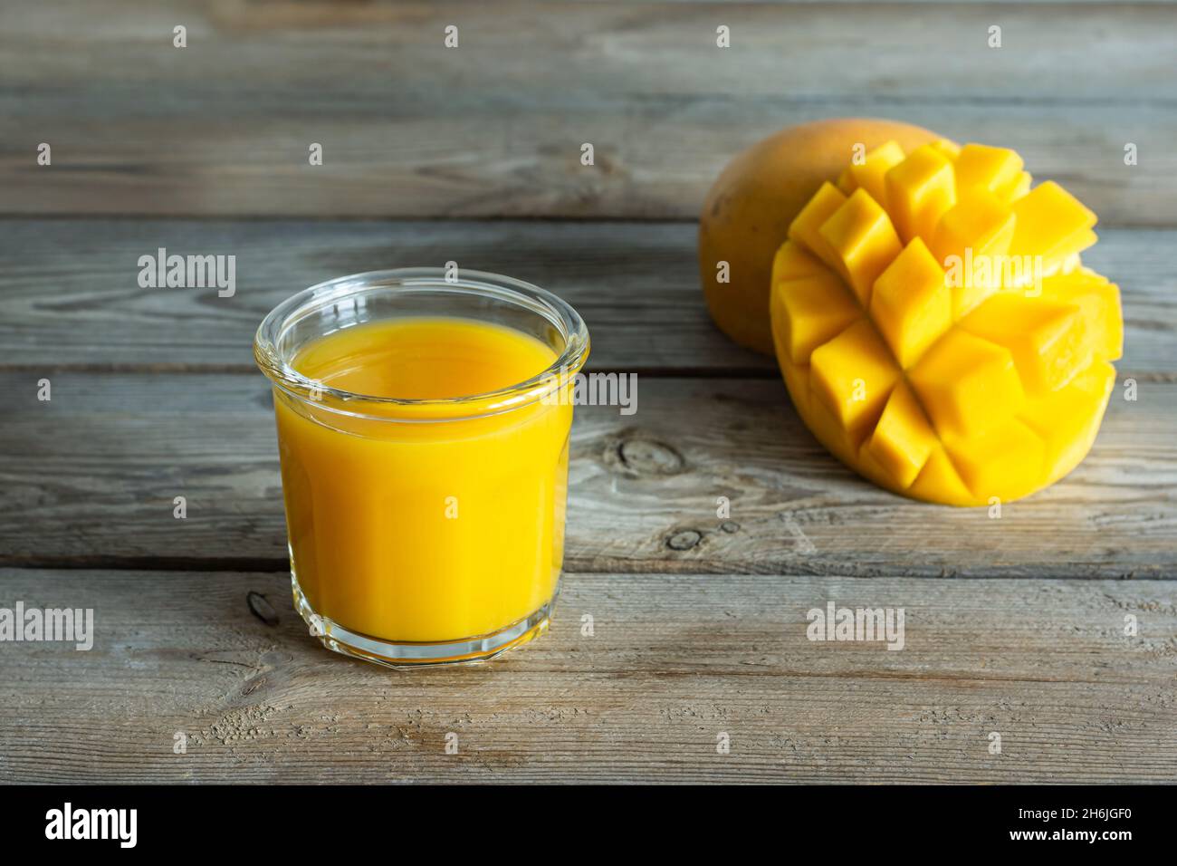 Fresh mango juice in a glass glass with mango slice on wooden ...