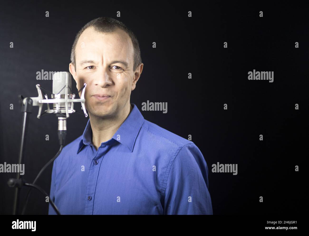 Voiceover artist voice actor in vocal recording studio with larg ...