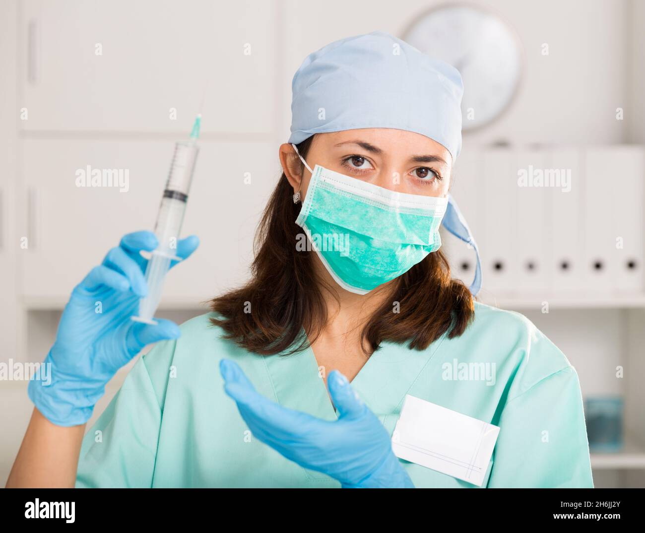 Female nurse in mask holding syringe for injection in hospital Stock ...