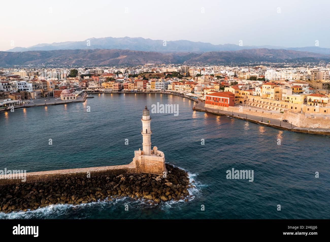 Sunrise over the Venetian lighthouse and harbour in the colorful town ...