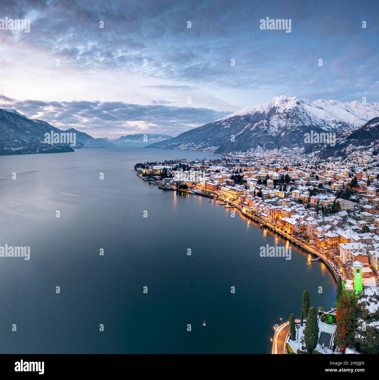 Winter sunrise over the illuminated lakeside town of Gravedona and ...