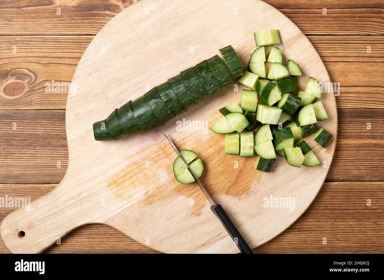 cutting fresh cucumber on a chop board Stock Photo - Alamy