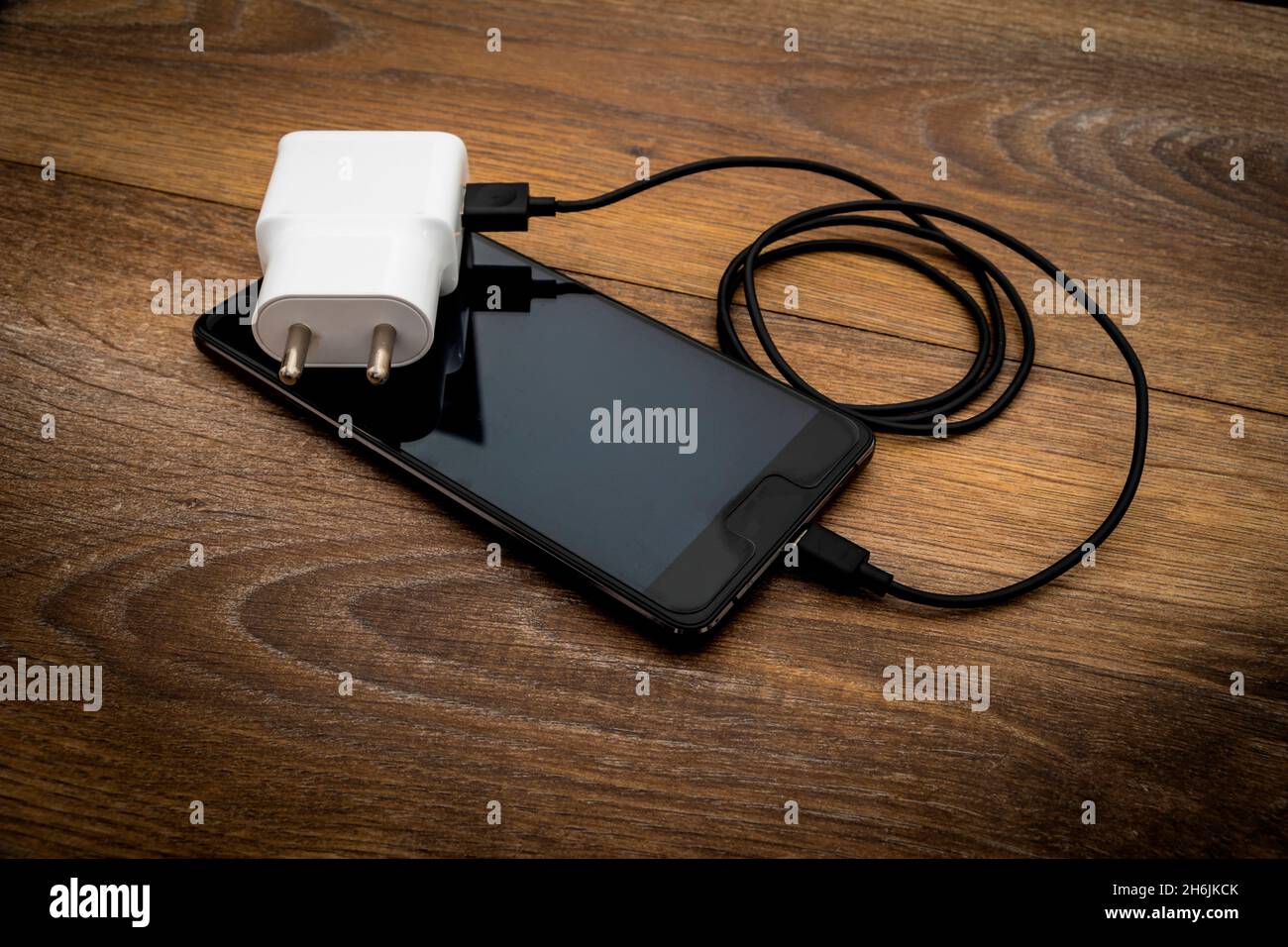 Mobile phone off with disconnected charger with wooden background Stock ...
