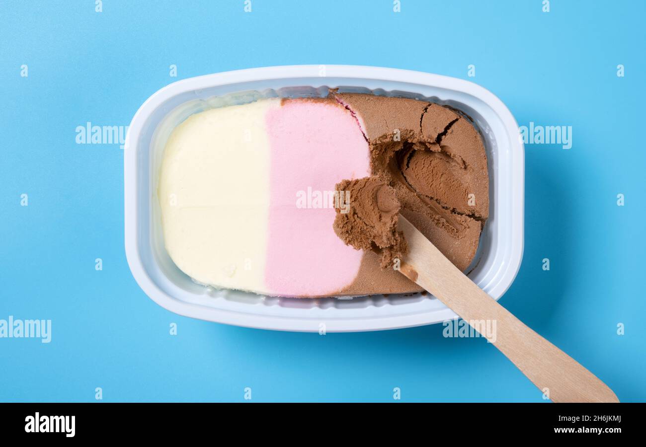 eating cup of multicolor ice cream on blue background Stock Photo - Alamy