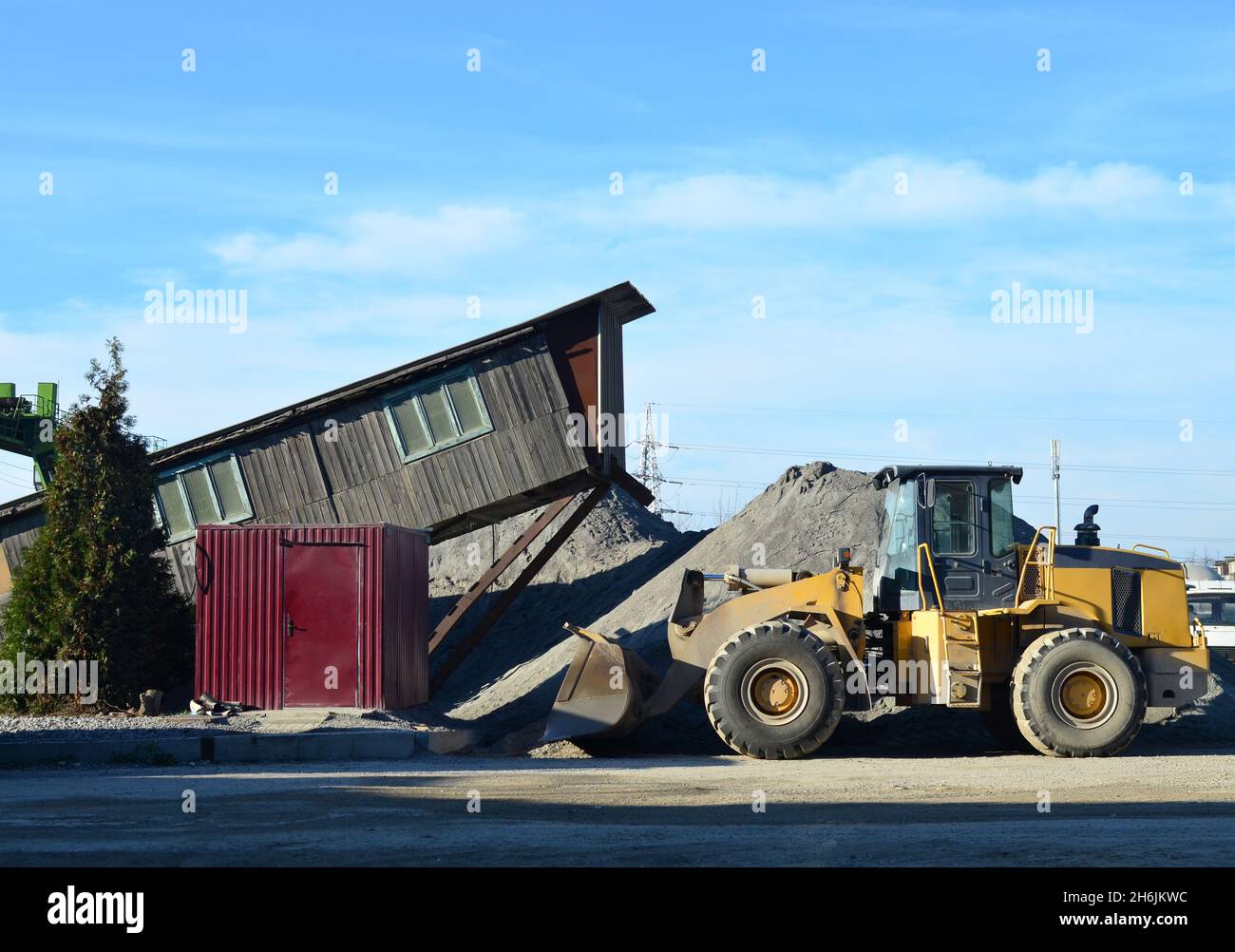 Wheel loader at construction site. Fron-end loader unloads crushed ...
