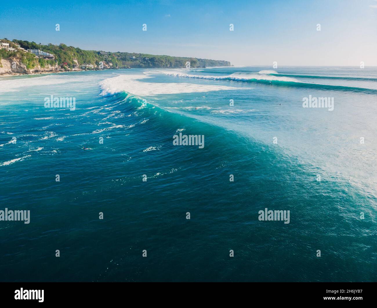 Aerial view in Bali with surfers and turquoise barrel wave in ocean ...