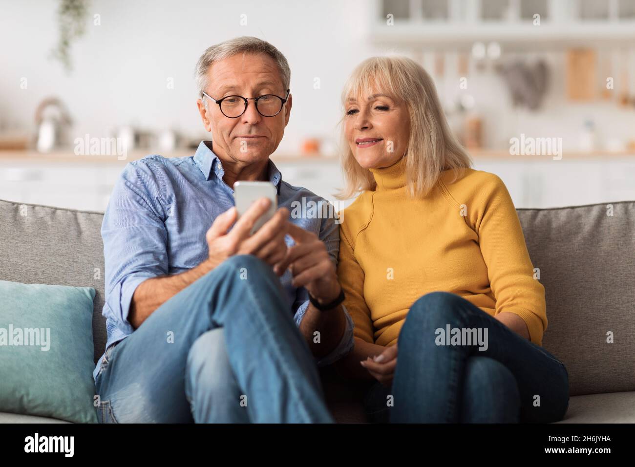 Senior Husband And Wife Using Smartphone At Home Stock Photo - Alamy