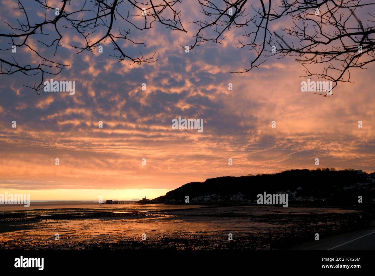 Mumbles village and seafront at sunrise with lighthouse and lifeboat ...