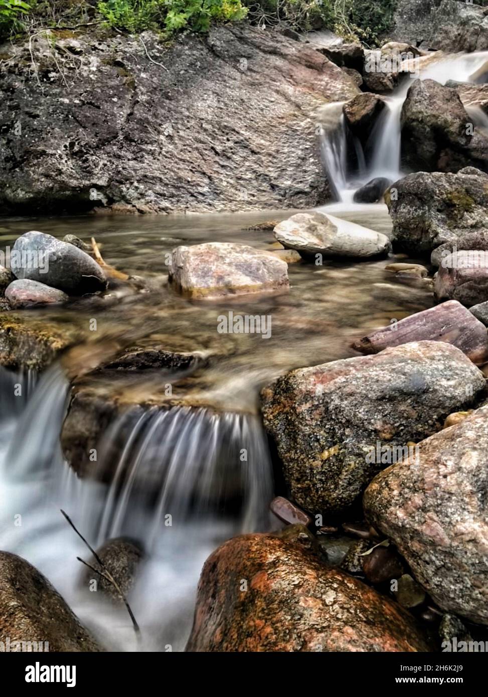 Beautiful view of the flowing rocky river surrounded by greens Stock ...