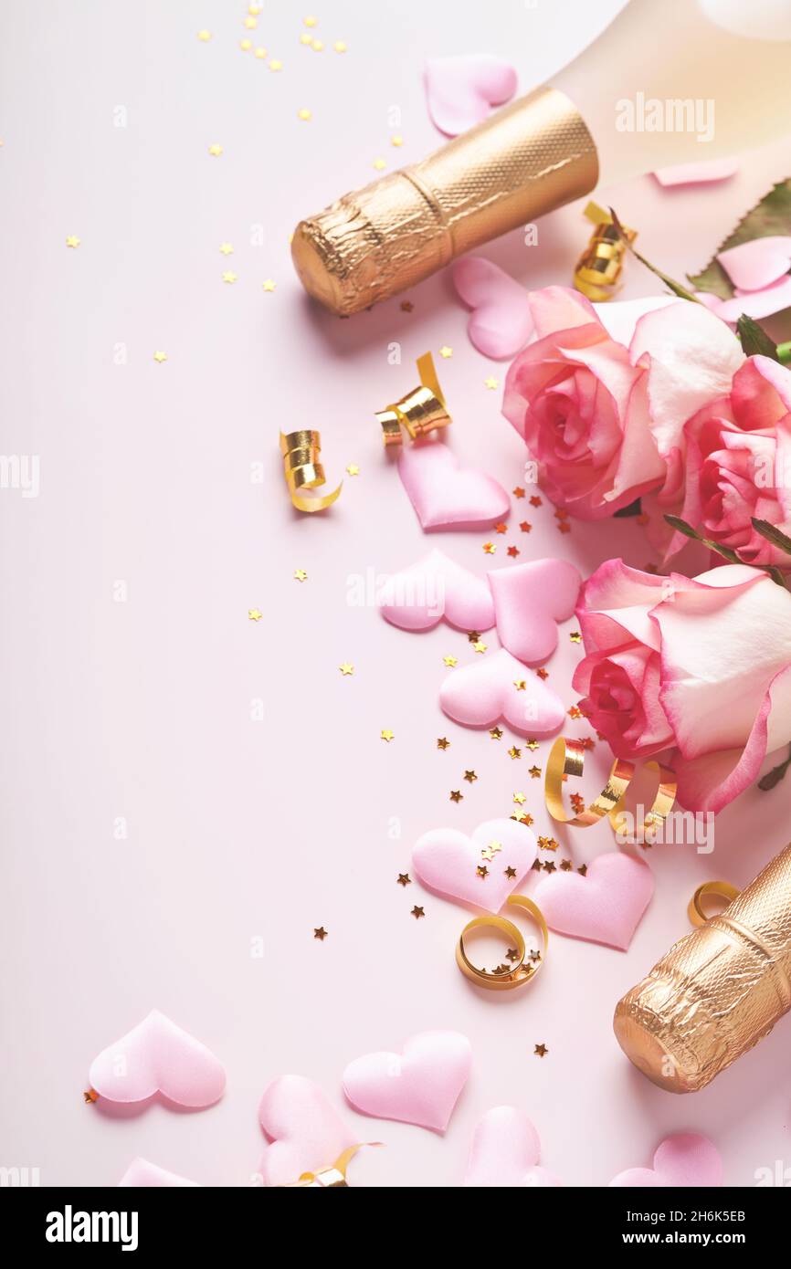 Pink roses flowers, champagne, gift, golden ribbons and confetti red ...