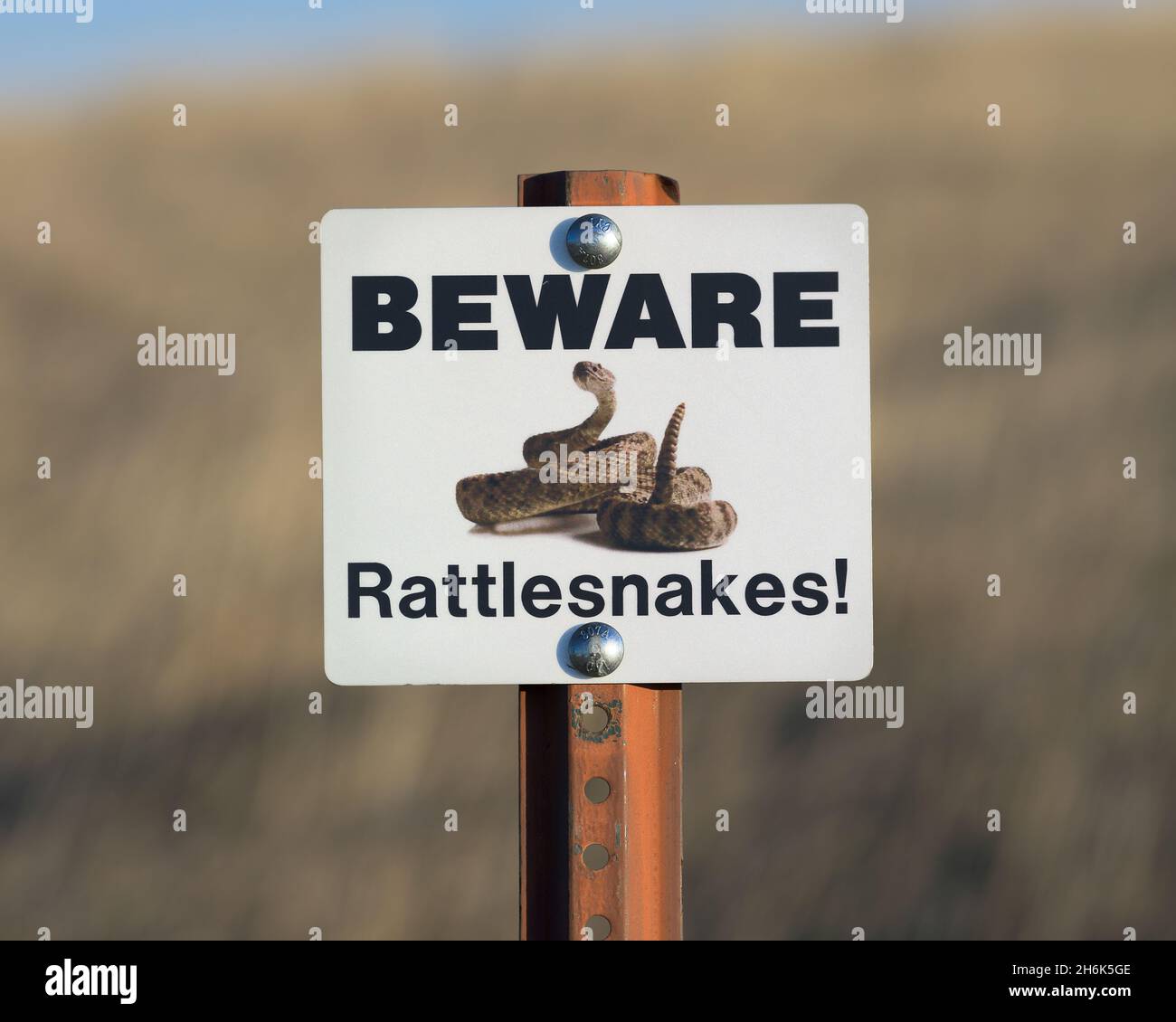 Beware of Rattlesnakes sign on post at Badlands National Park in South ...