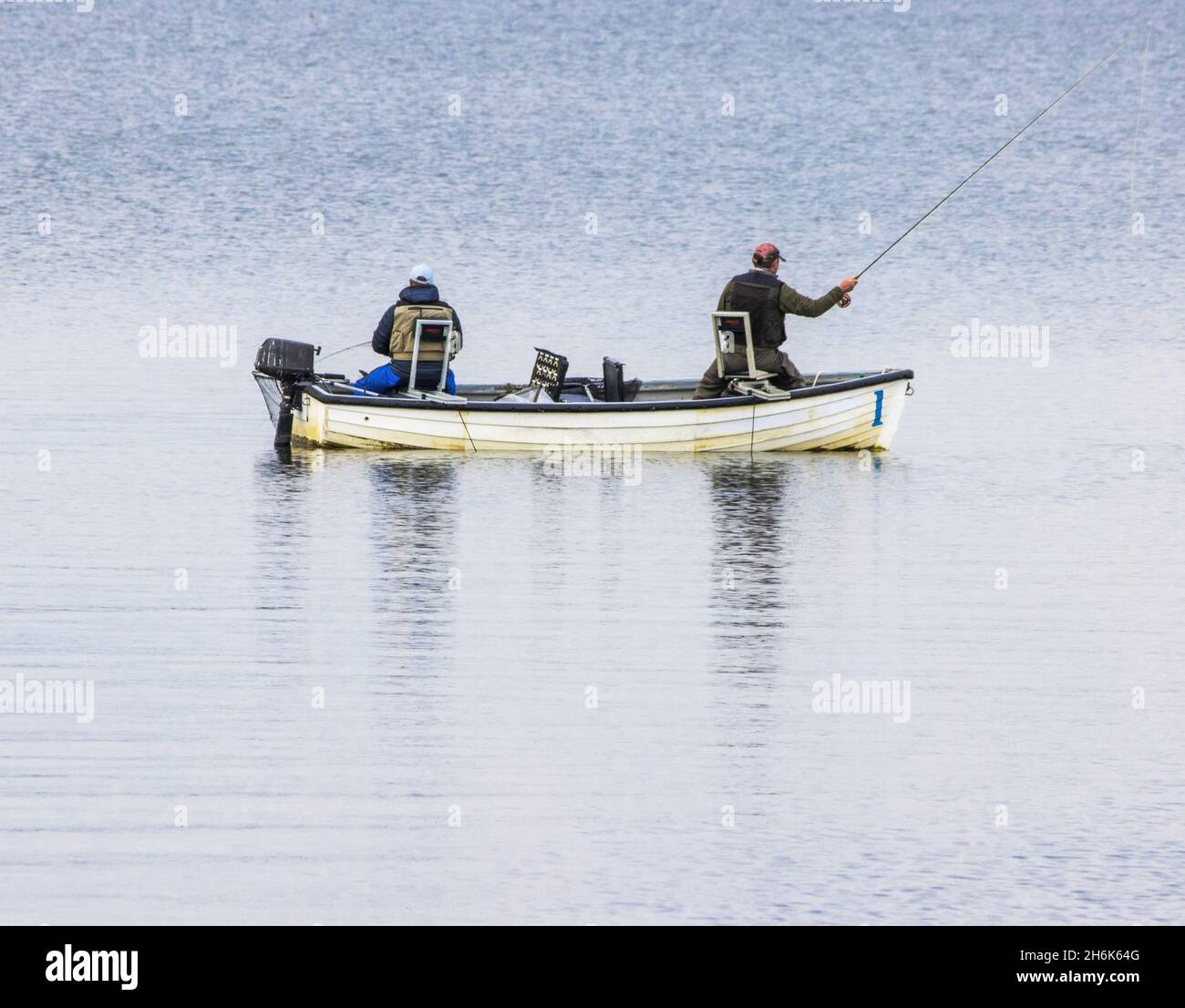 Two men fishing in a boat Stock Photo - Alamy