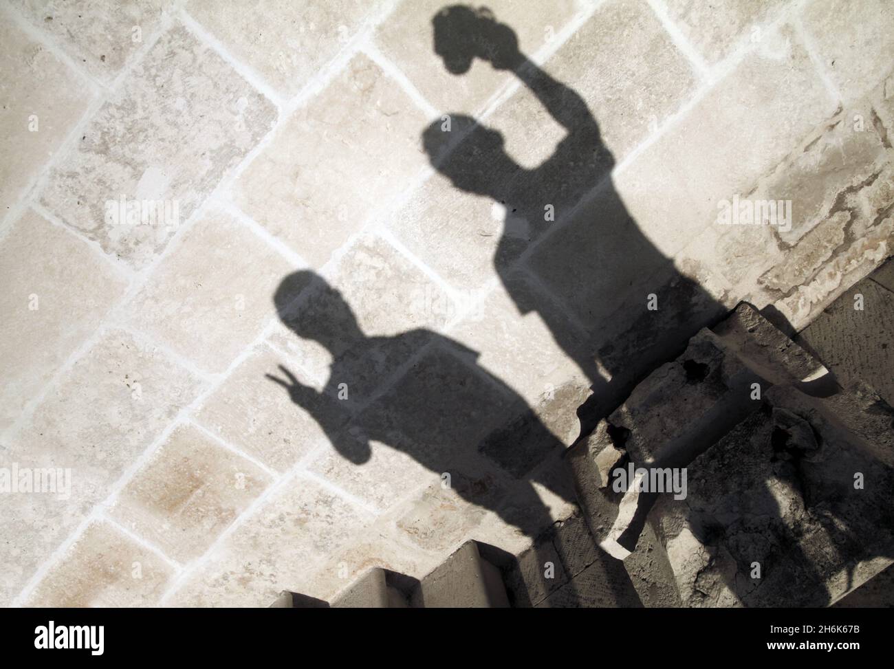 People taking photos of their shadows on the ground Stock Photo - Alamy