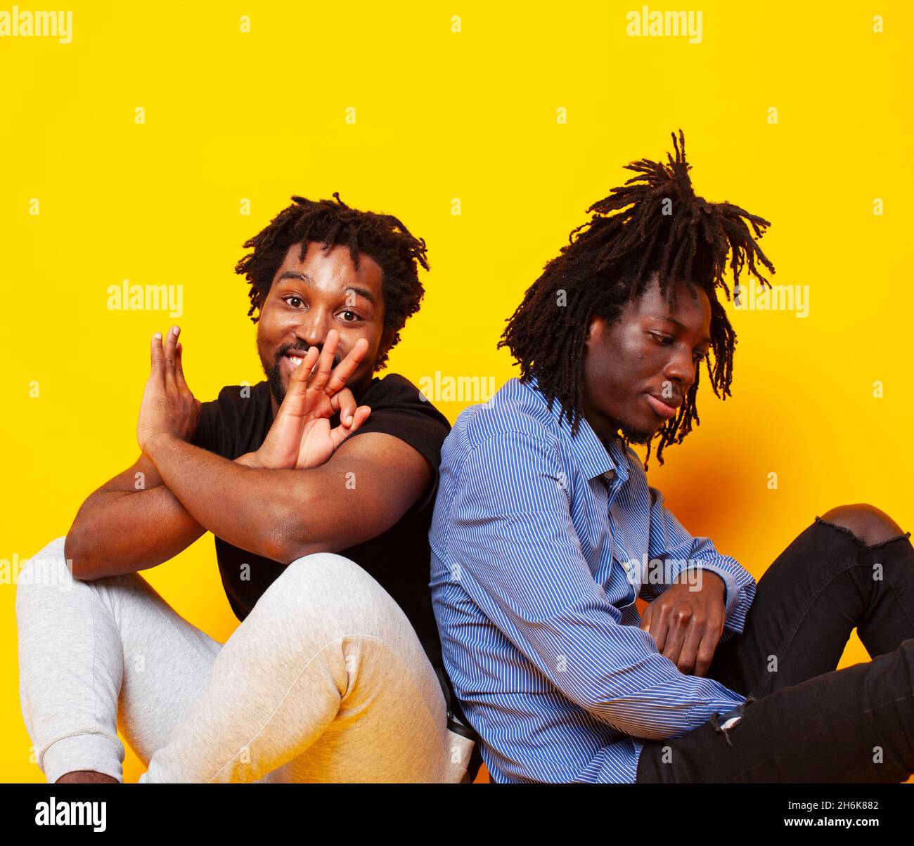 two african american guys posing cheerful together on yellow background ...