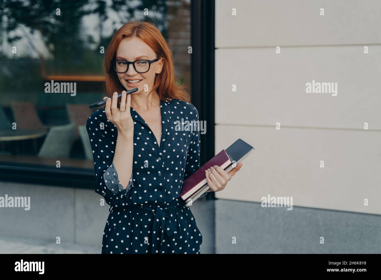 Beautiful smiling business woman using speakerphone or virtual voice ...