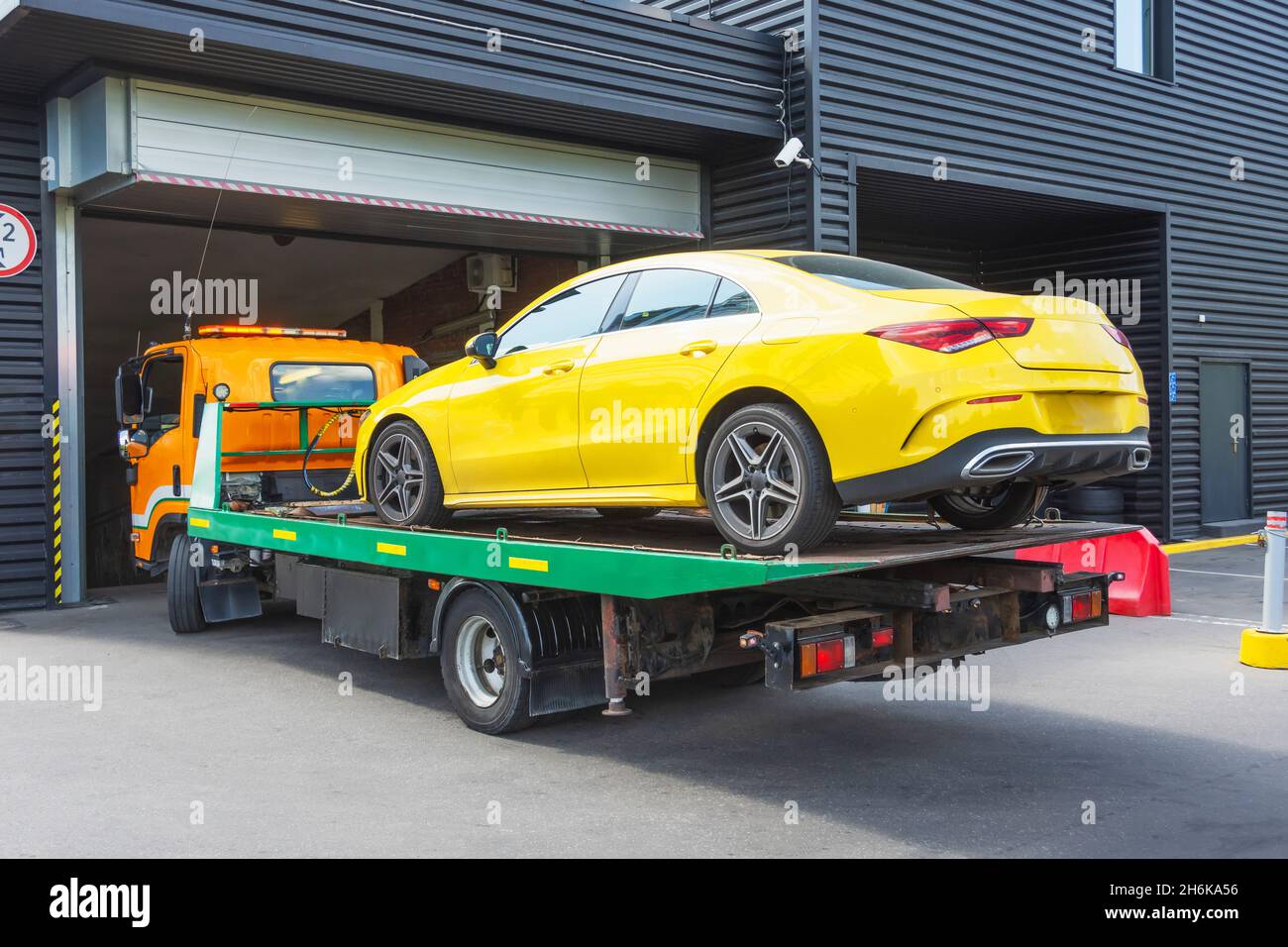 Tow truck delivers a new car by entering an underground garage with an ...
