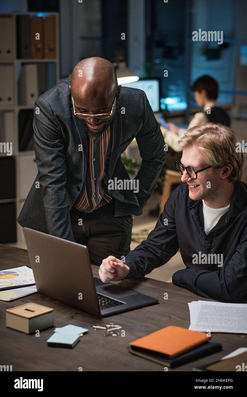 Business colleagues looking at the screen of laptop smiling, they ...