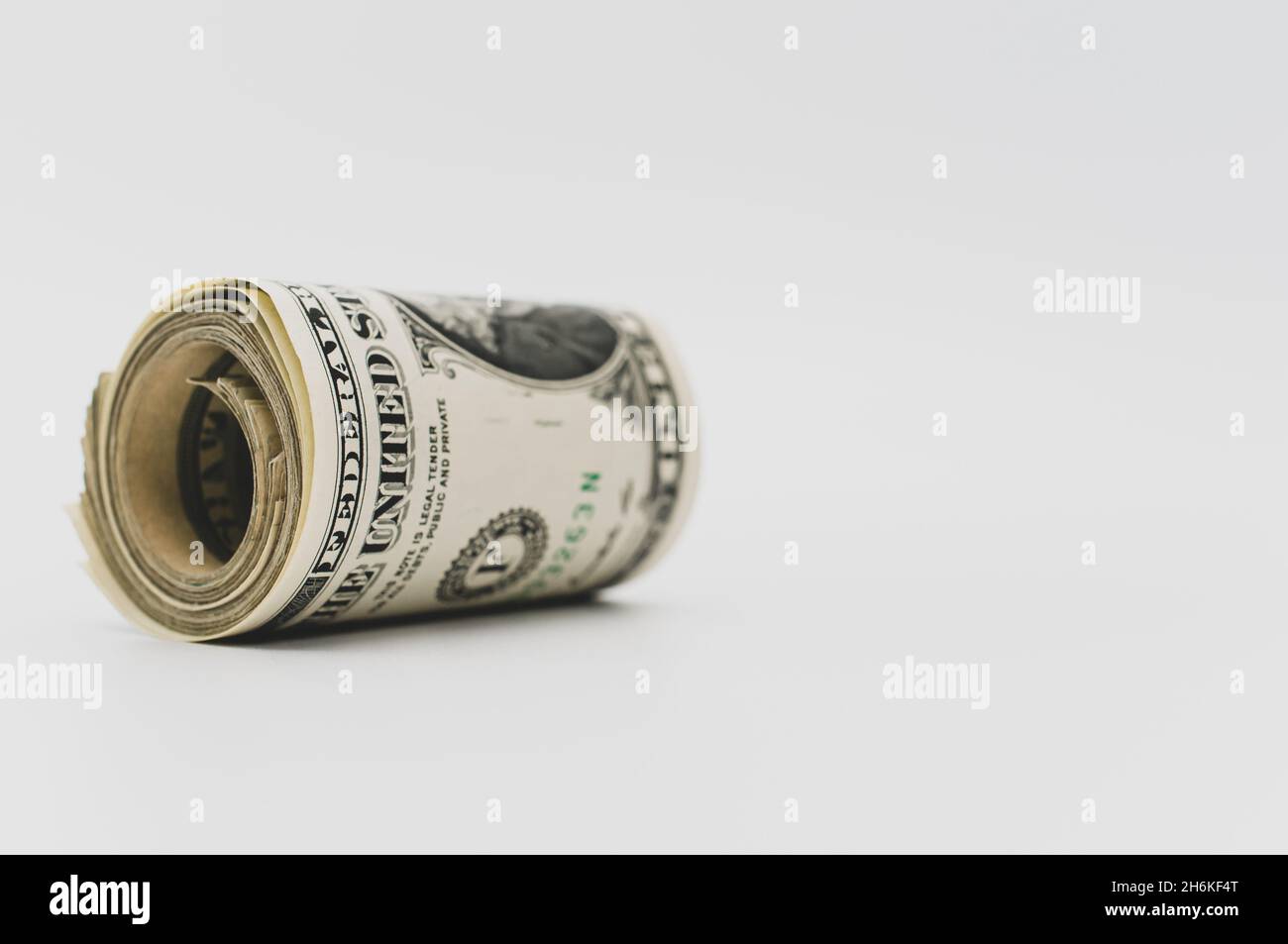 isolated US dollar banknotes roll on a white background with copy space ...