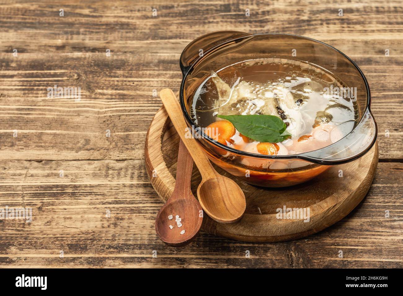 Transparent chicken broth. Low fat clear soup with carrot, greens and ...