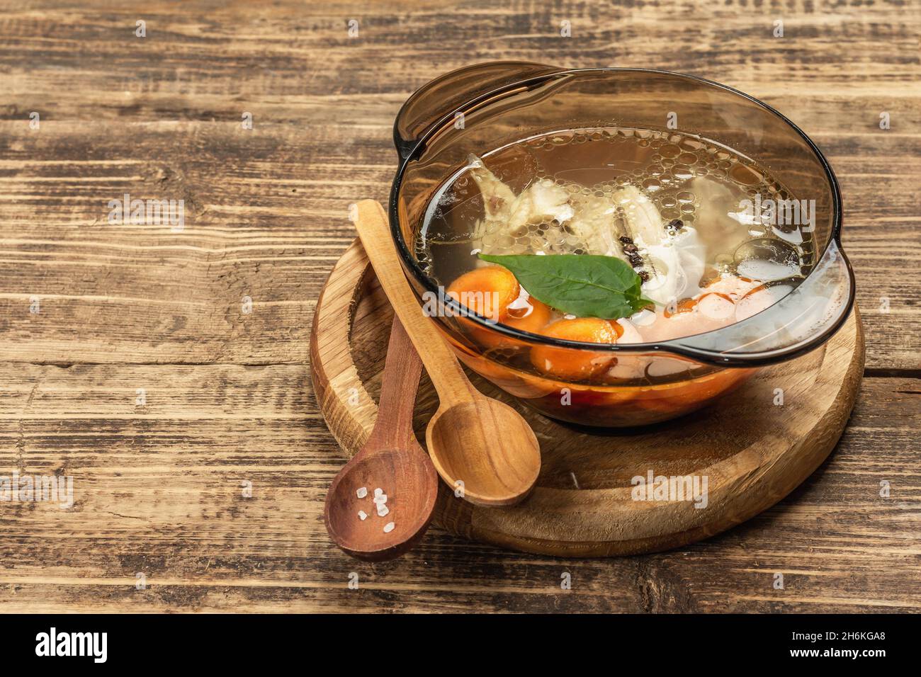 Transparent chicken broth. Low fat clear soup with carrot, greens and ...