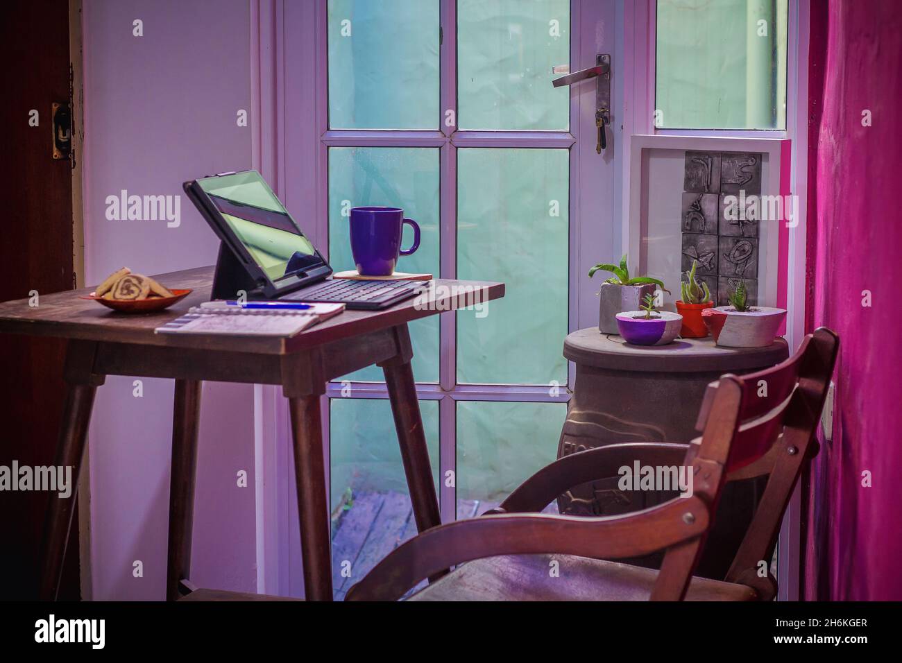 Notebook beside pastries, pen, and a cup of coffee on a wooden table ...