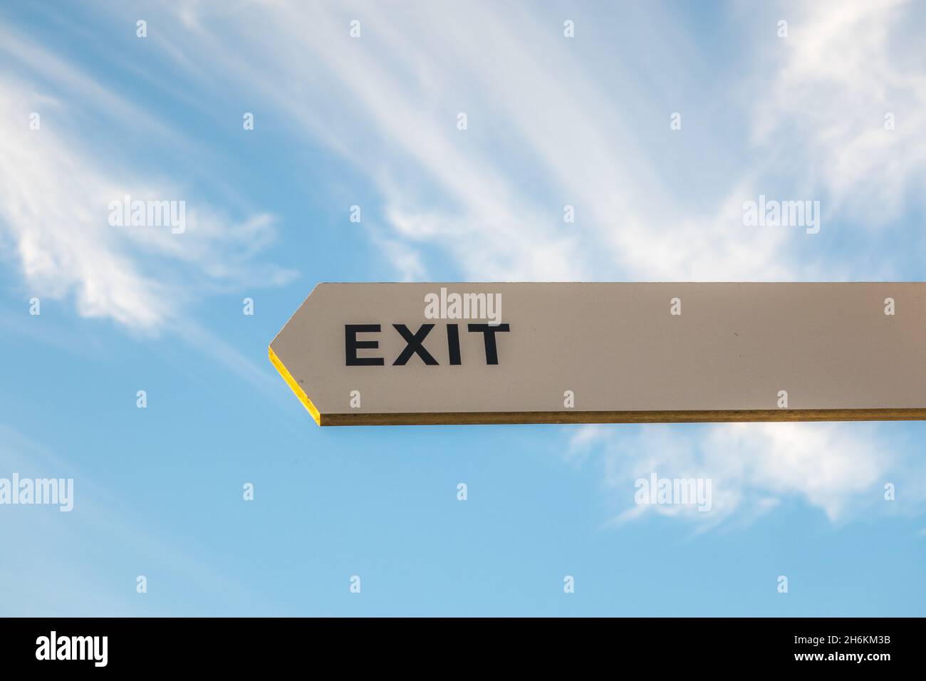 Simple exit sign pointing to left against a sky Stock Photo - Alamy