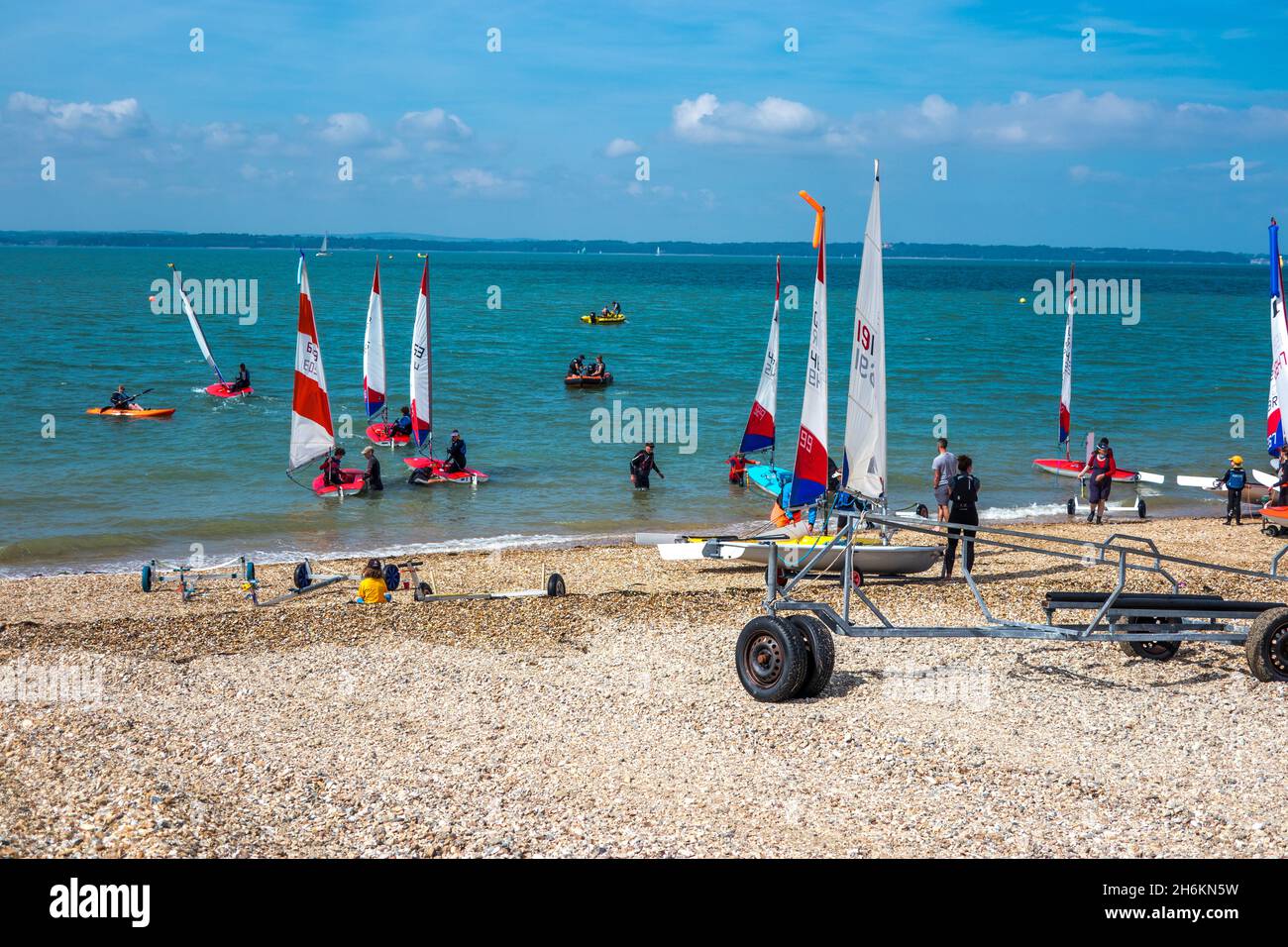 Topper sailing boats on Solent sea and beach at Stokes Bay is a shingle ...