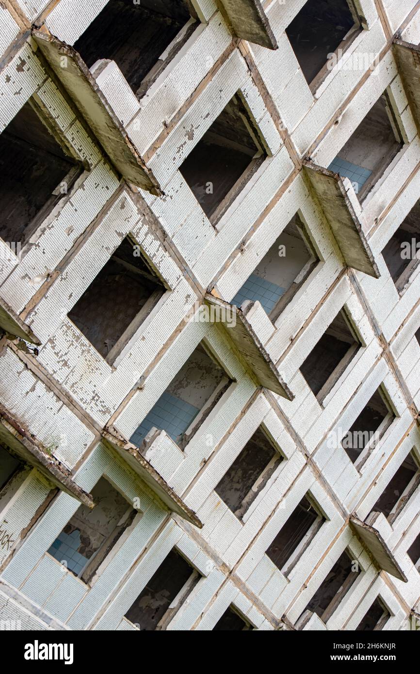 A damaged abandoned panel house with decorative facade of small white ...
