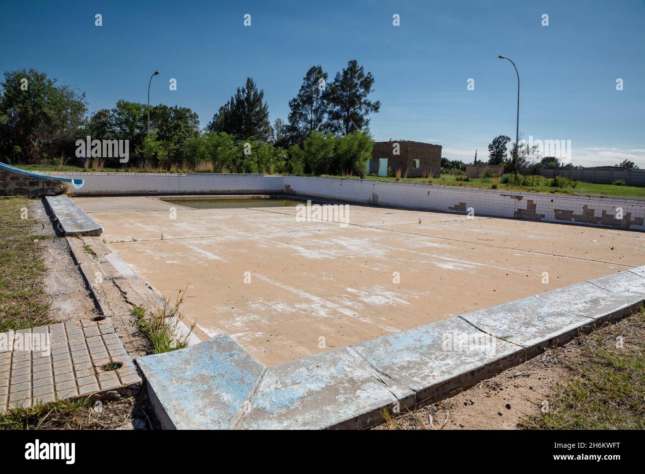 Empty and abandoned large swimming pool with huge concrete slabs ...