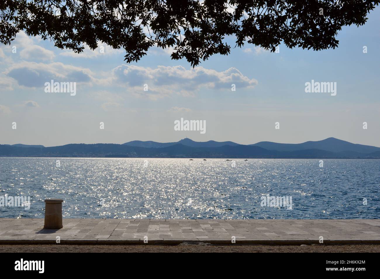 View of beautiful landscape with islands silhouettes and sun reflecting ...
