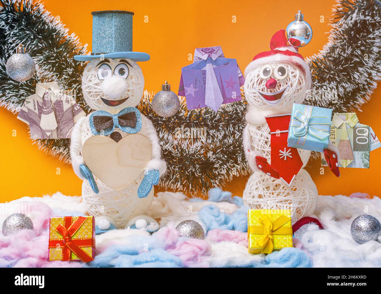 Two playful and funny Christmas snowmen are holding wooden heart and ...
