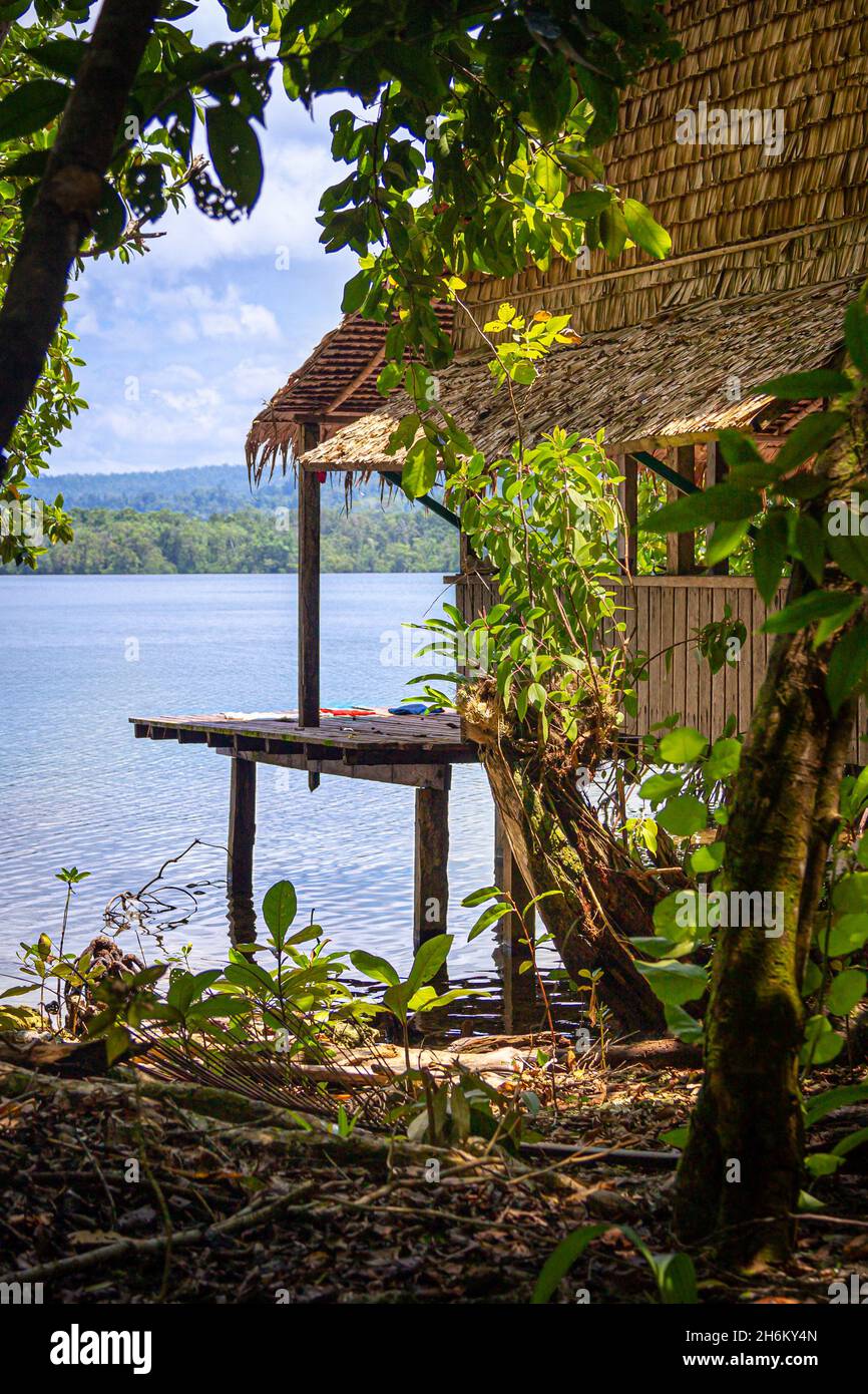 Traditional hut overlooking calm lagoon waters in the Solomon Islands ...