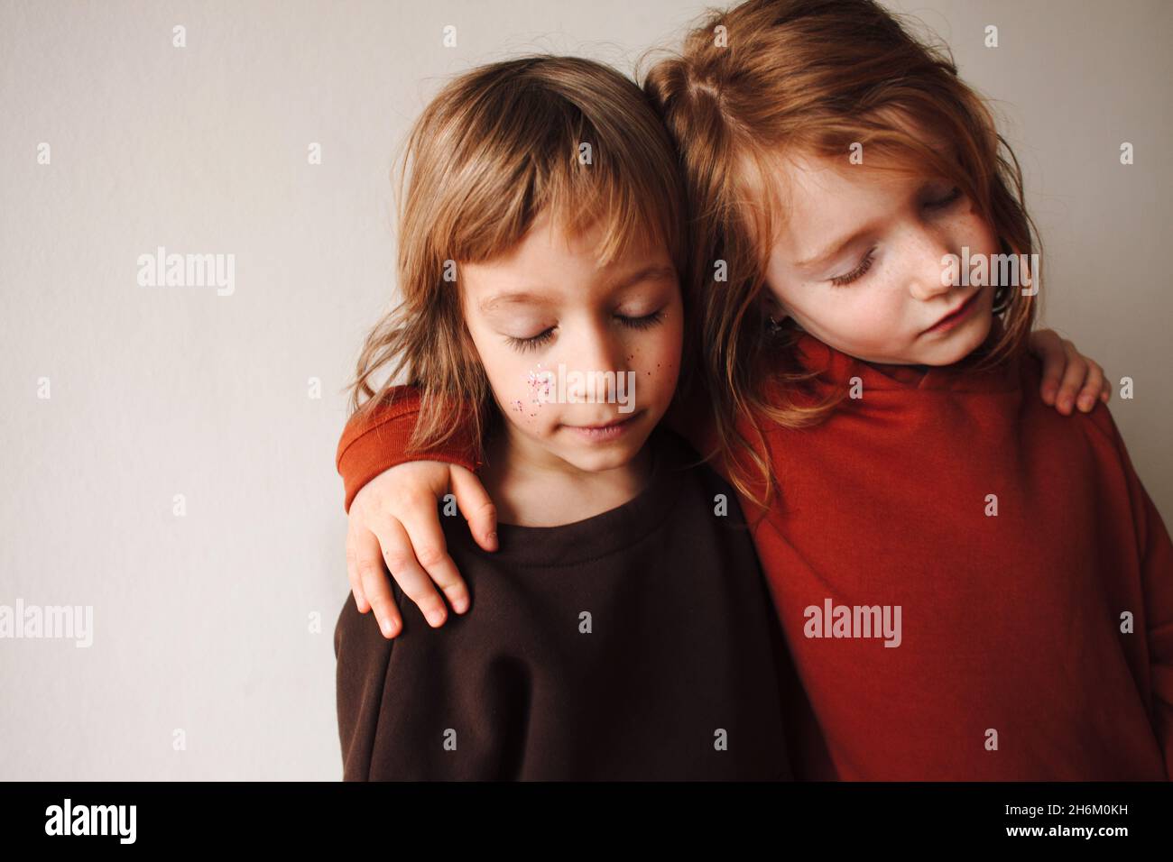 Two little girls best friends with closed eyes hugging Stock Photo - Alamy