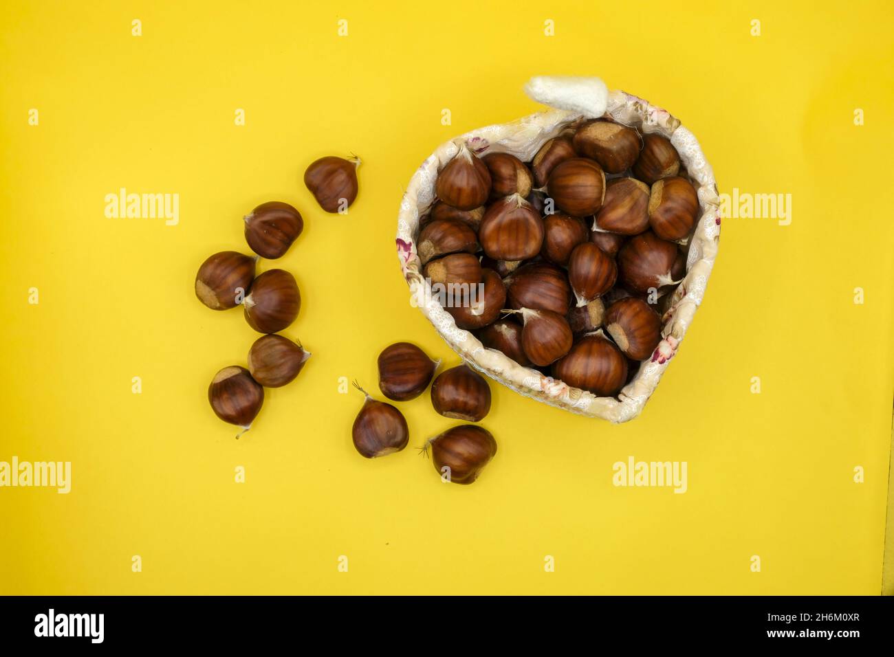 Top view of a pile of hazelnuts in a heart shaped container on the ...