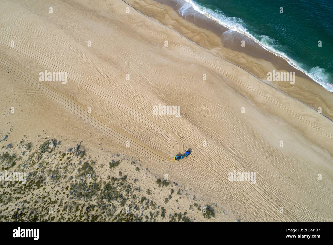 Aerial view of the wavy sea hitting the sandy beach on the coast Stock ...