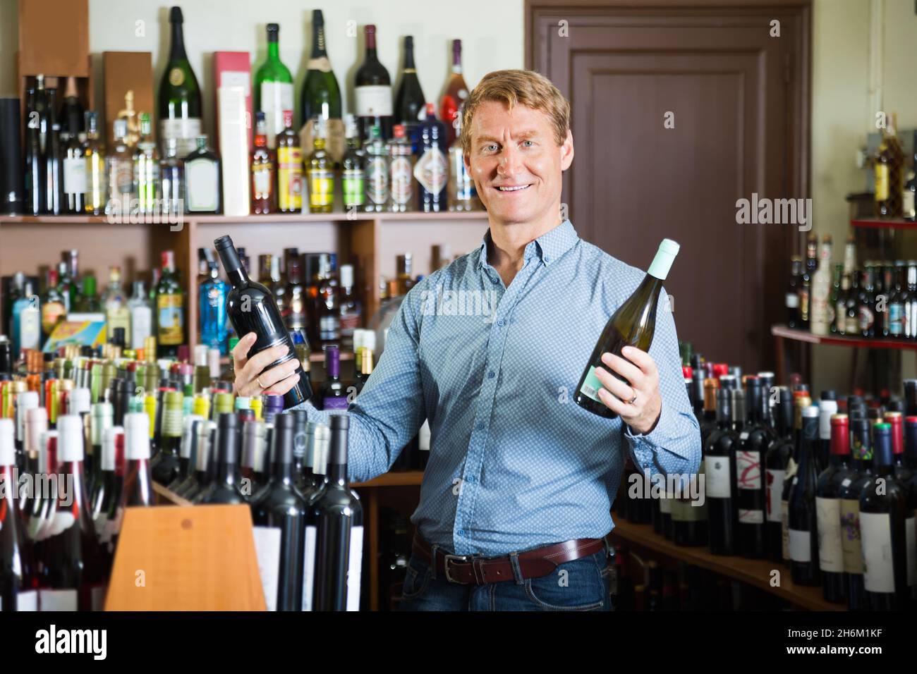 customer picking bottles in wine store Stock Photo - Alamy