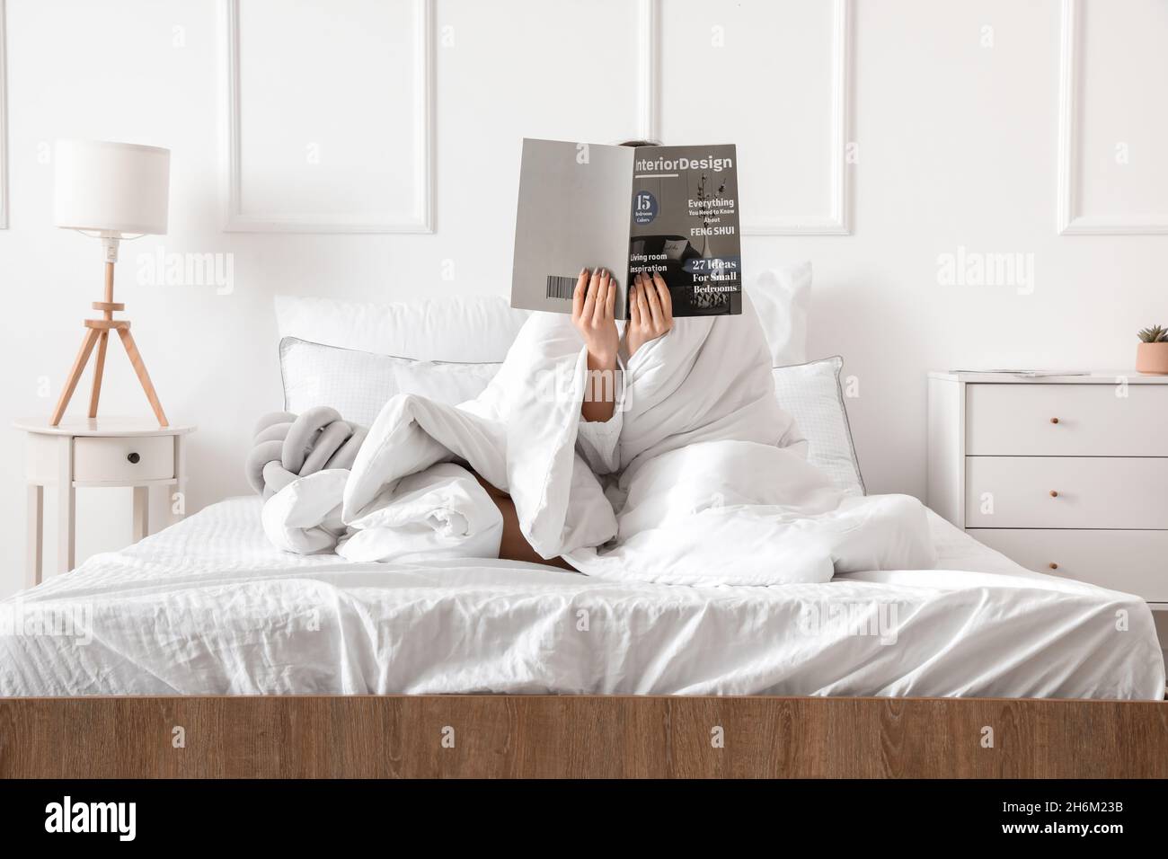Morning of young woman reading magazine in bed Stock Photo - Alamy
