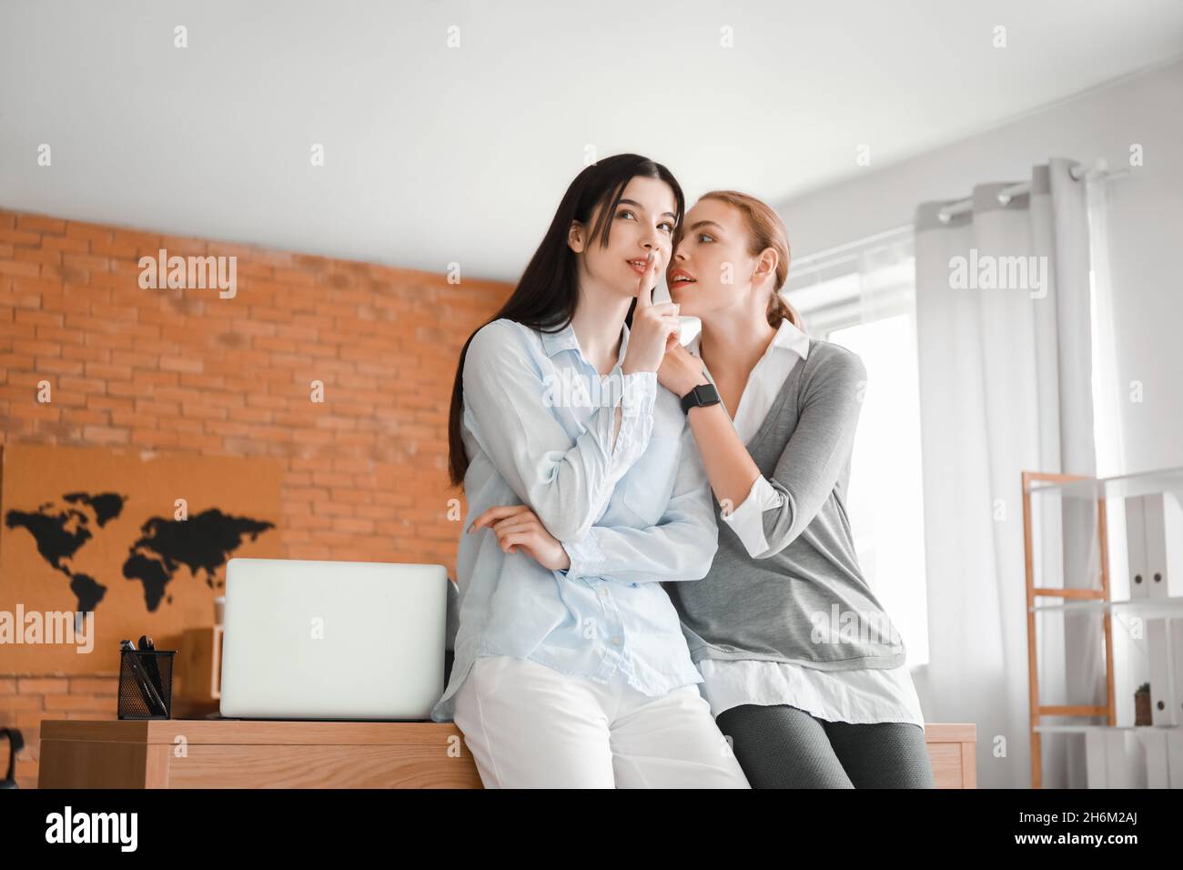 Female colleagues gossiping in office Stock Photo - Alamy
