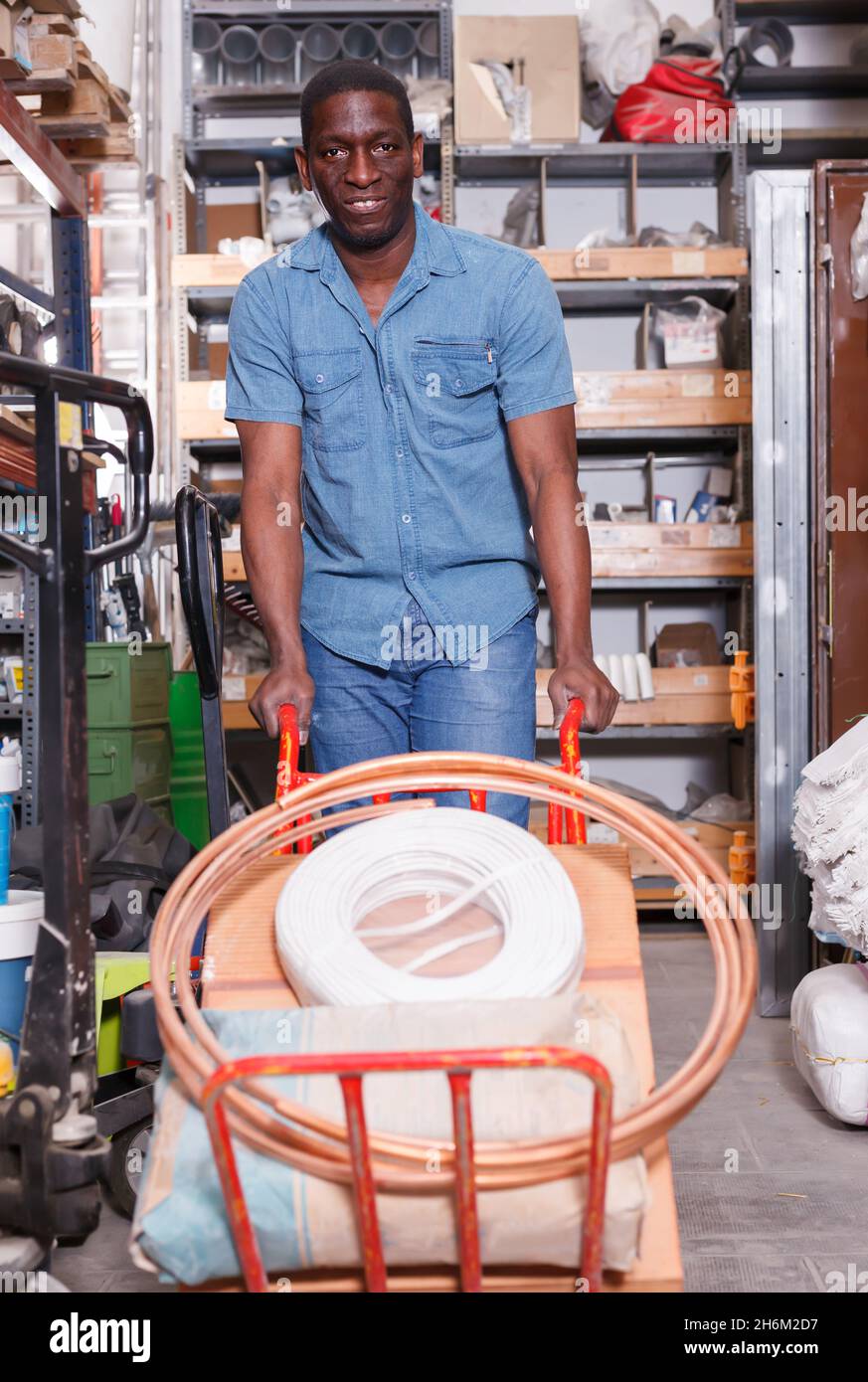 Glad African American pushing trolley cart Stock Photo - Alamy