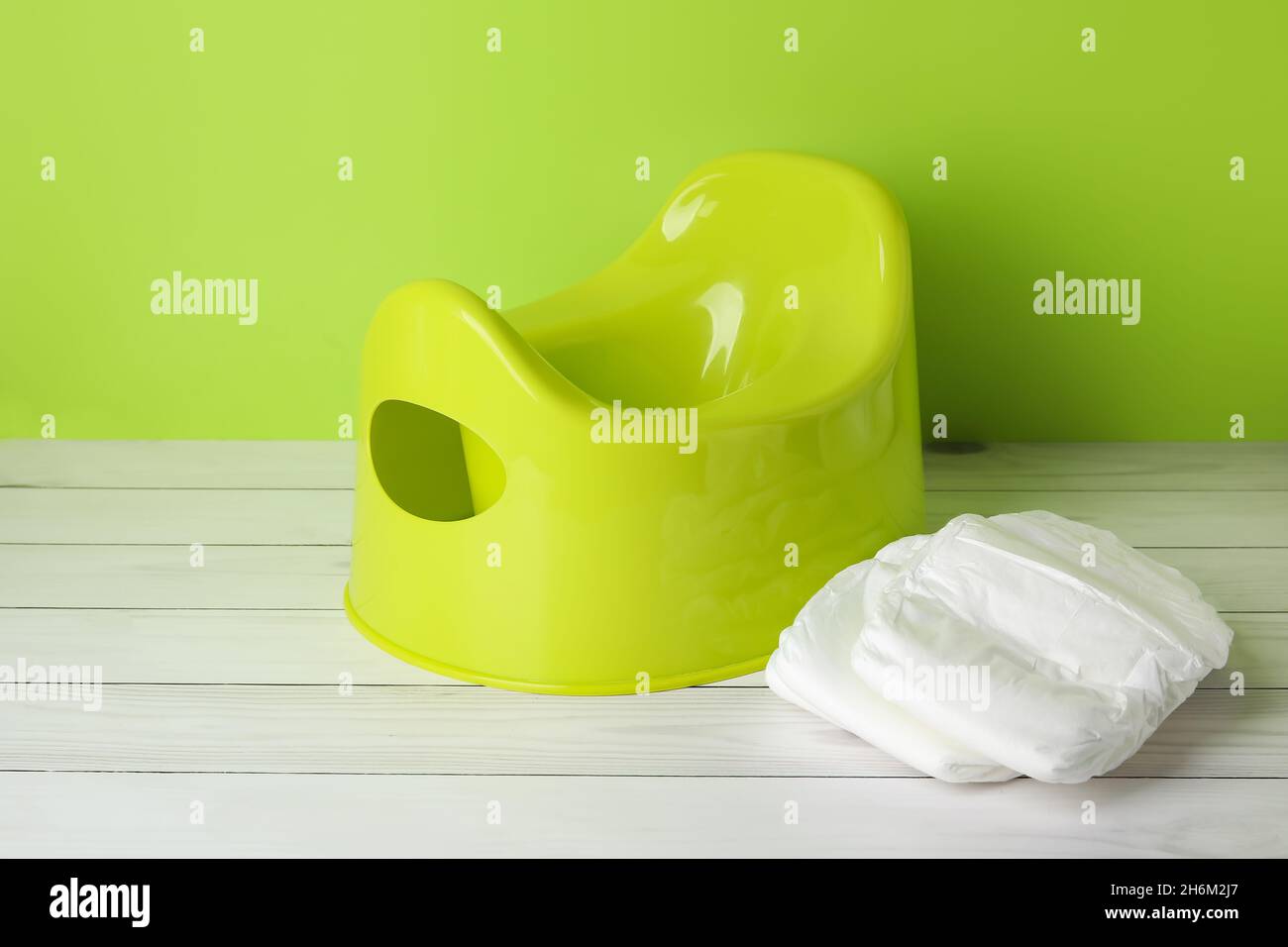 Potty and diapers on white wooden floor near color wall Stock Photo - Alamy