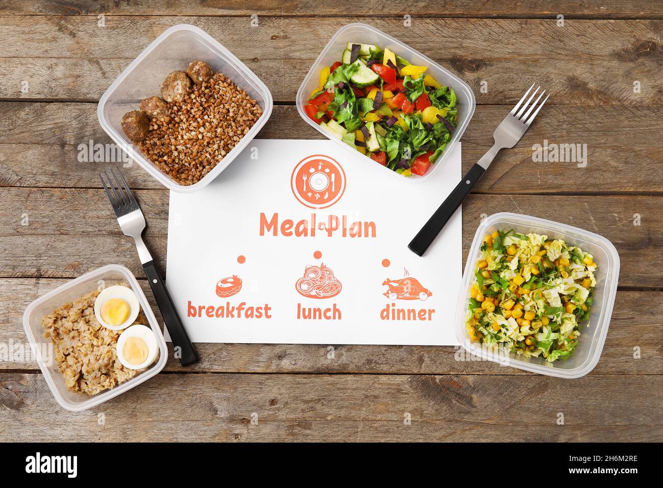 Containers with delicious healthy food, forks and meal plan on wooden ...