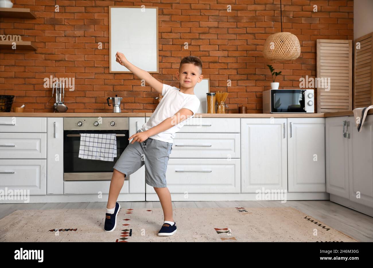 Cute little boy dancing in kitchen Stock Photo - Alamy